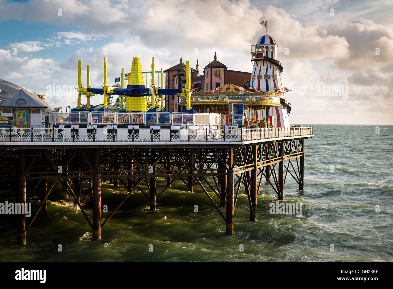 The funfair at the end of Brighton Pier is lit by the evening sun Stock ...