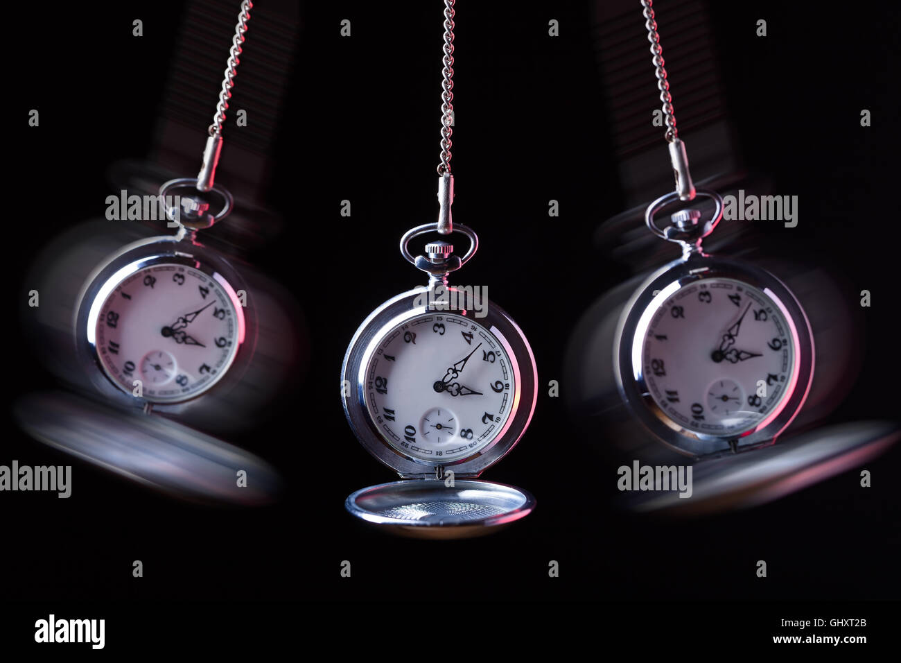 Pocket watch swinging on a chain to hypnotise , black background Stock ...