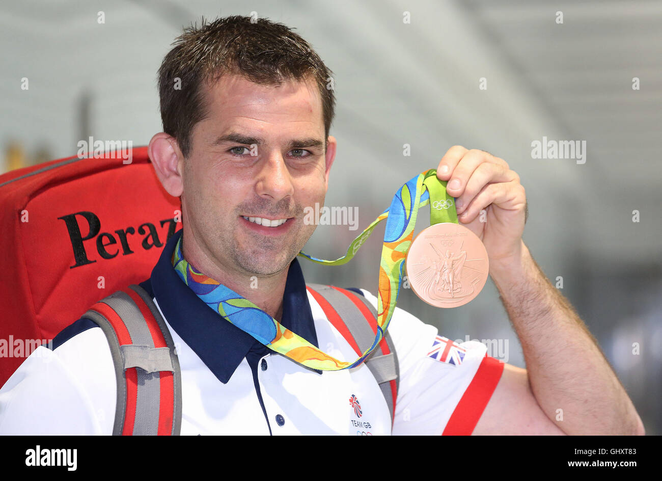 Ed Ling holding his medal after he arrives back at Heathrow airport ...