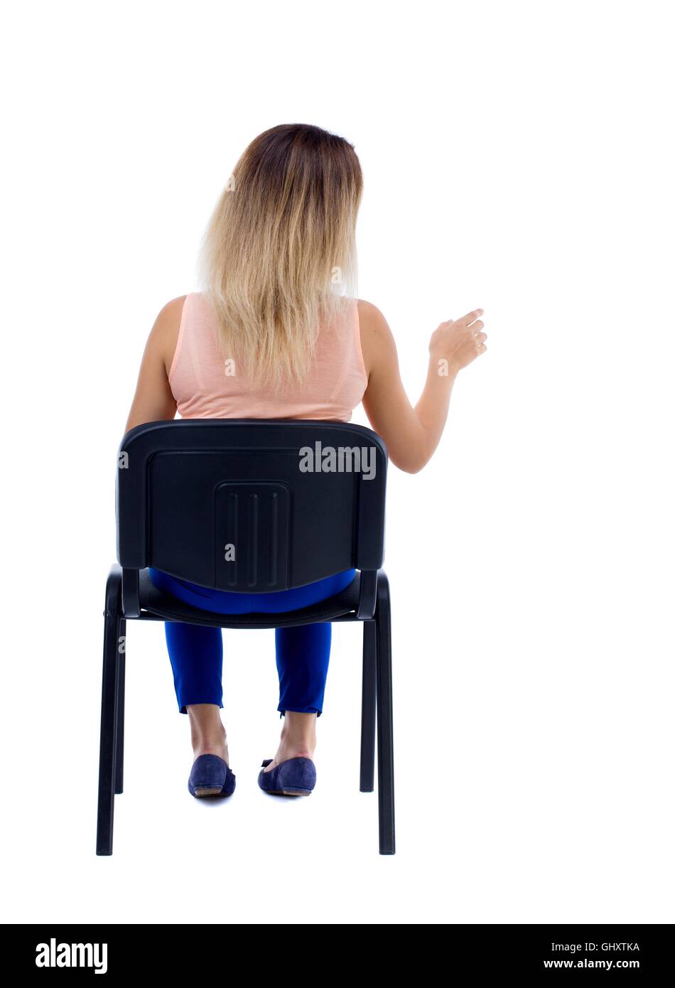 back view of young beautiful woman sitting on chair and pointin Stock ...