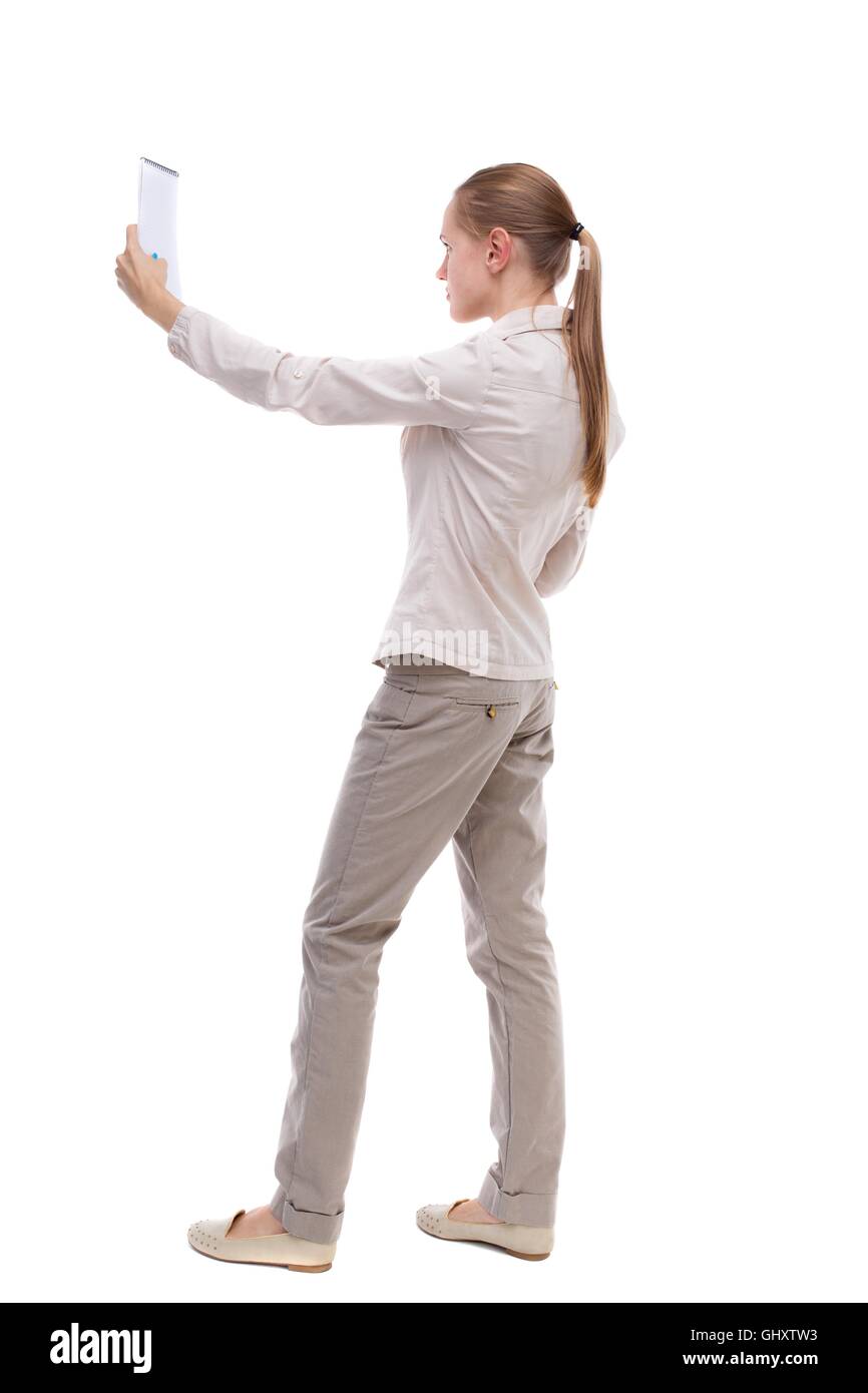 back view of stands woman takes notes in a notebook. girl watc Stock ...