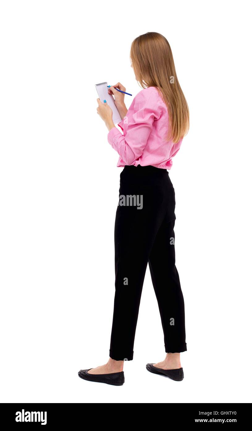 back view of stands woman takes notes in a notebook. girl watc Stock ...