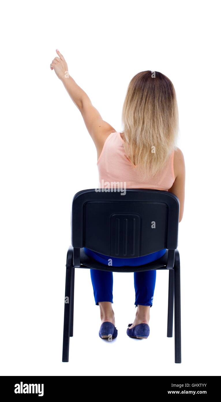 back view of young beautiful woman sitting on chair and pointin Stock ...