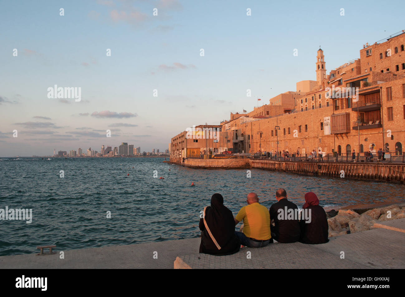Israel: a muslim family seated at the port of Jaffa with view of the ...