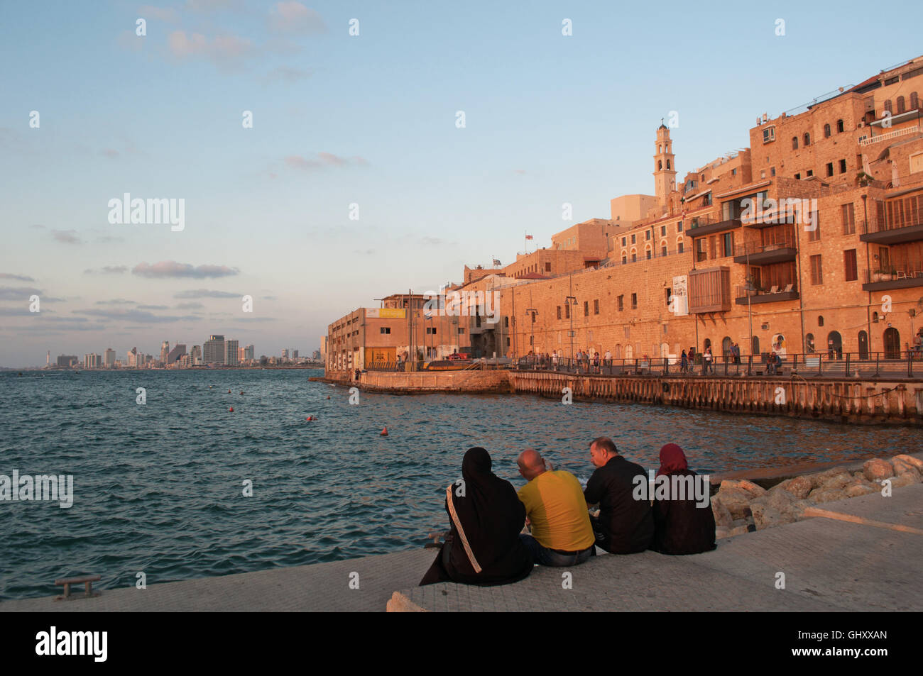 Israel: a muslim family seated at the port of Jaffa with view of the ...