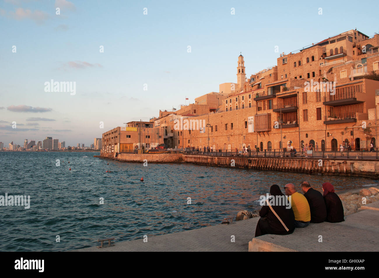 Israel: a muslim family seated at the port of Jaffa with view of the ...