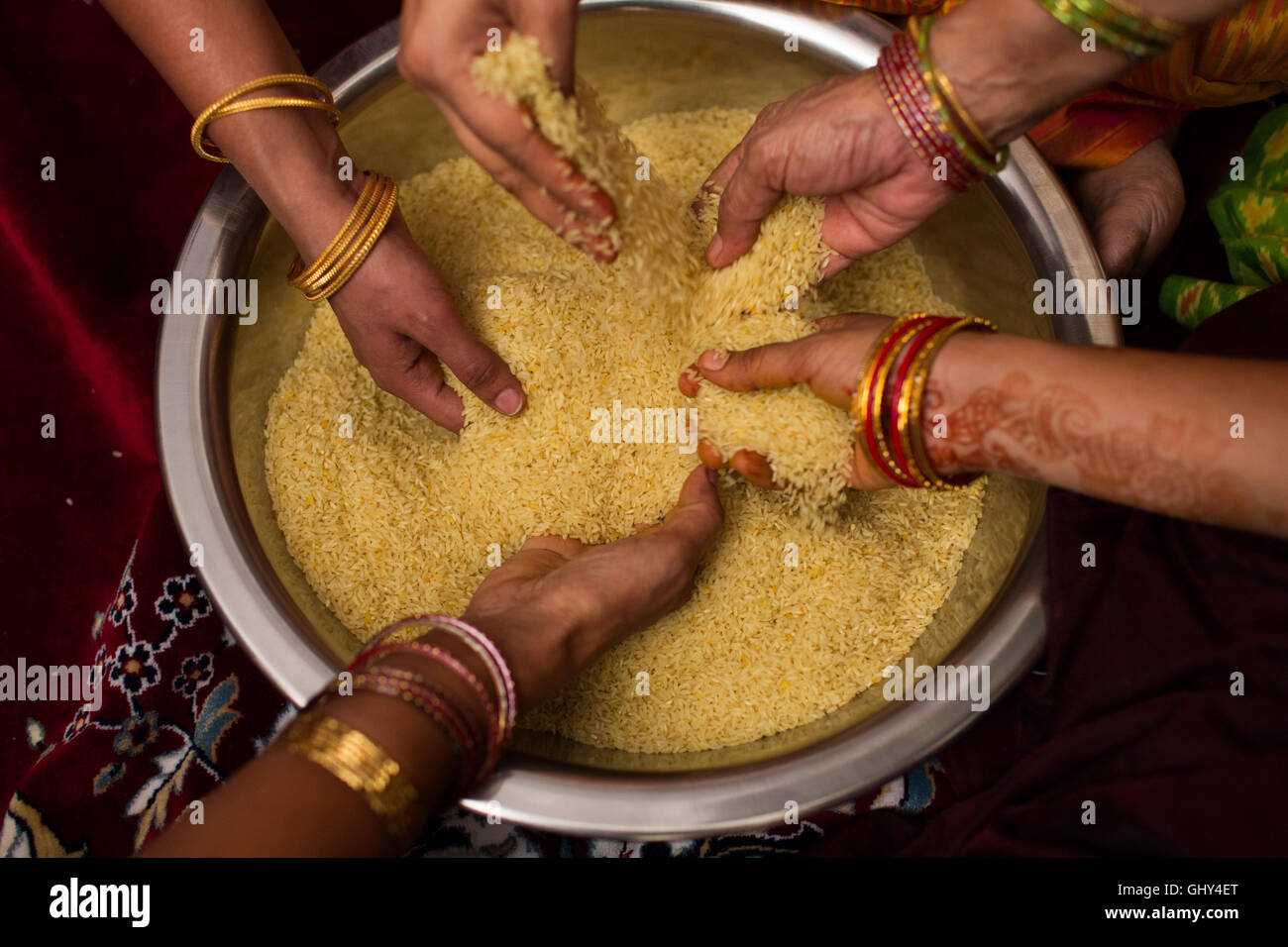 Indian Women mix rice with turmeric to be used in Hindu Rituals during ...