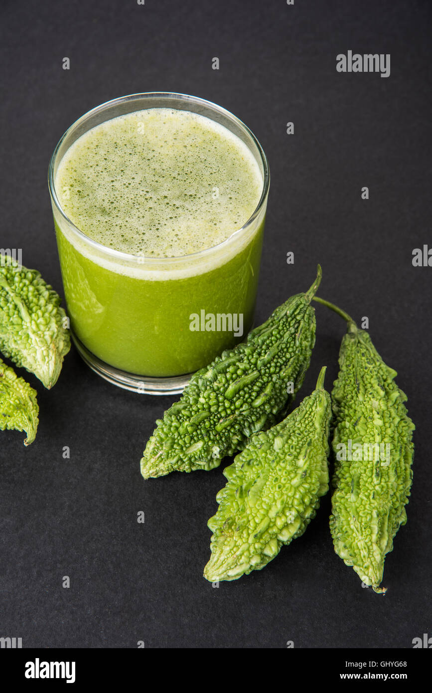 Herbal juice of green momodica in a glass with sliced vegetables ...