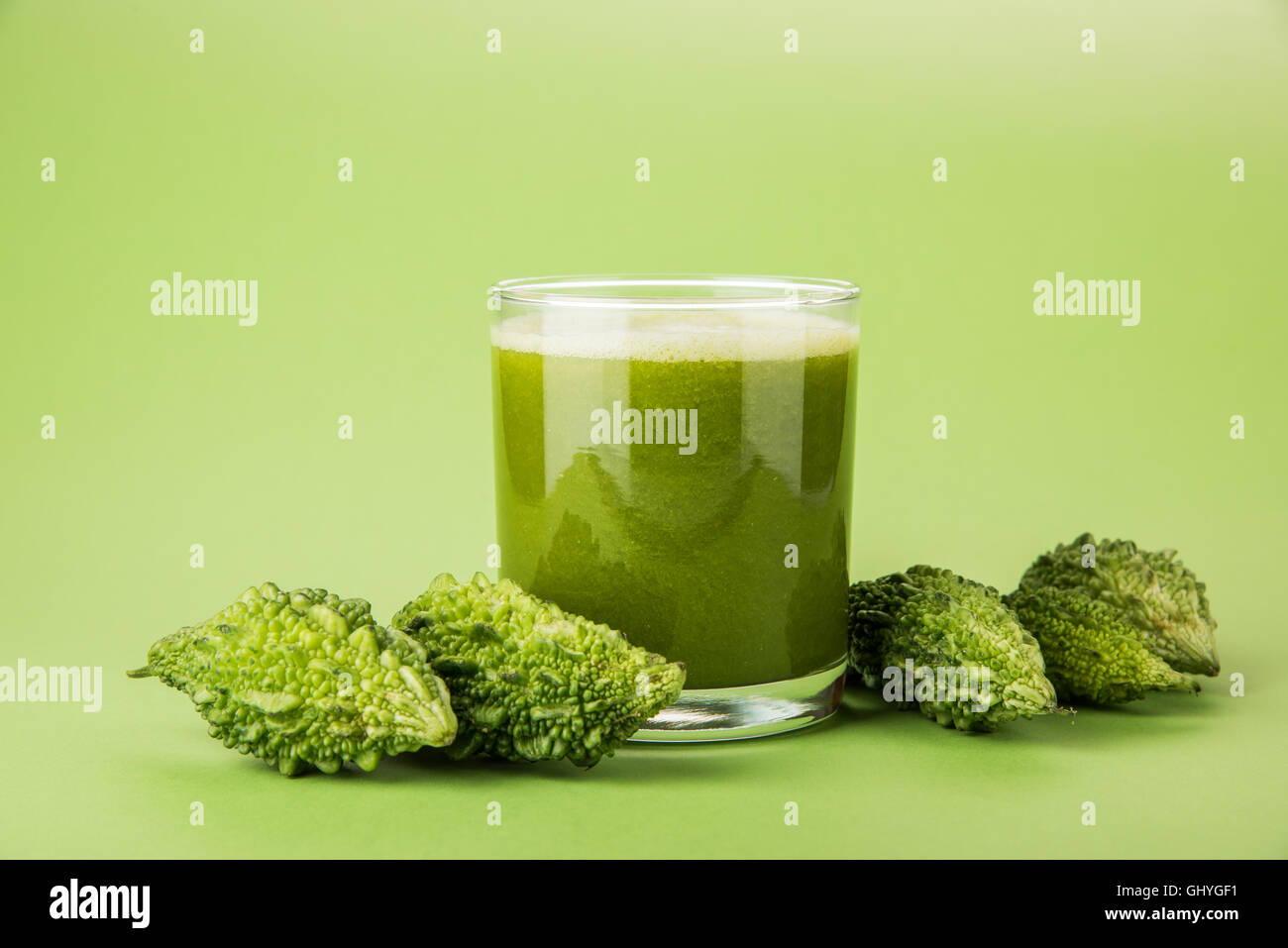 Herbal juice of green momodica in a glass with sliced vegetables ...