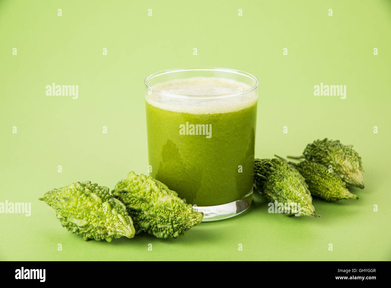 Herbal juice of green momodica in a glass with sliced vegetables ...