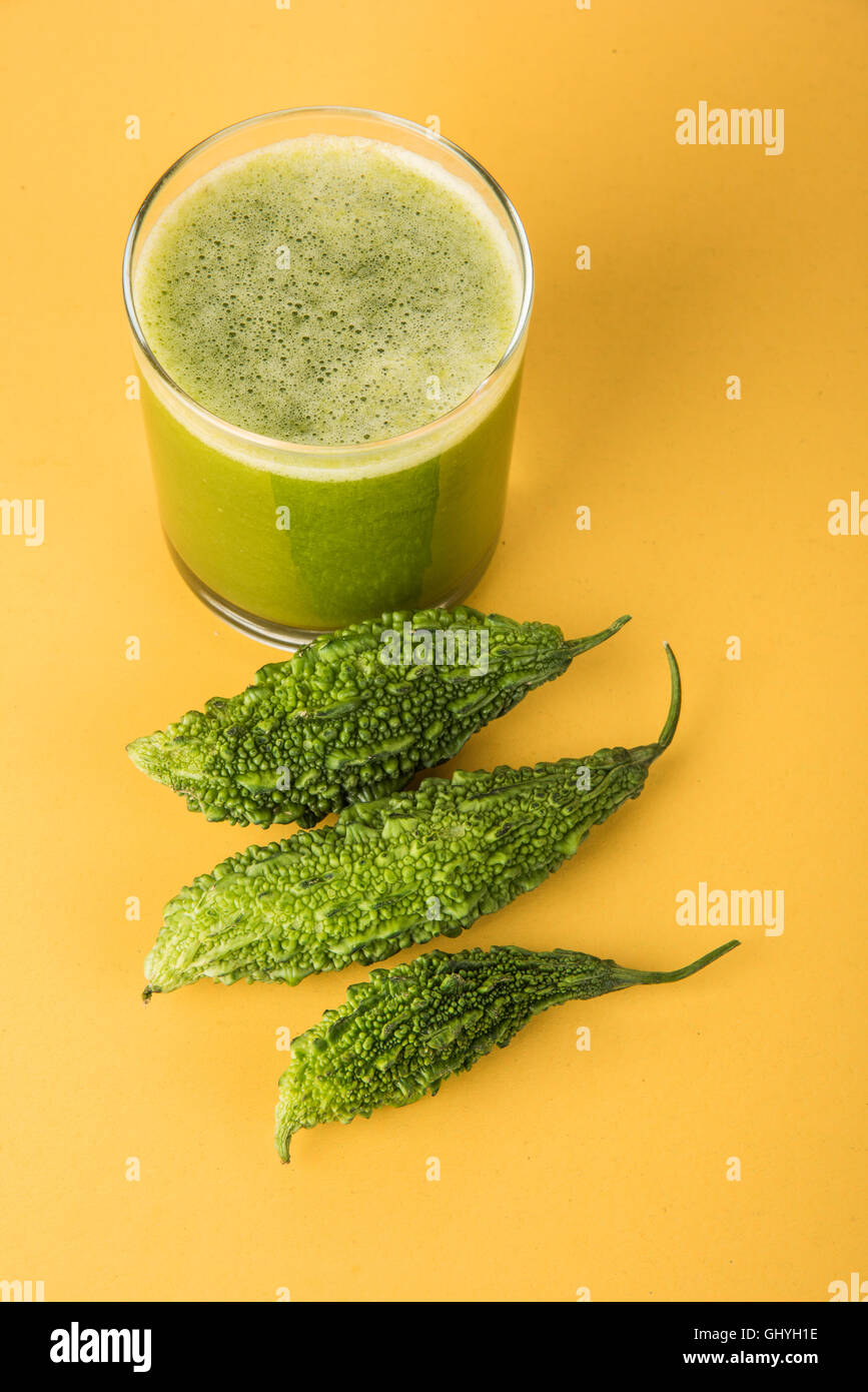 Herbal juice of green momodica in a glass with sliced vegetables ...