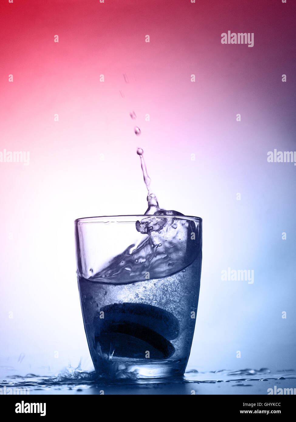 two Lemon drop and splash in a water glass Stock Photo - Alamy