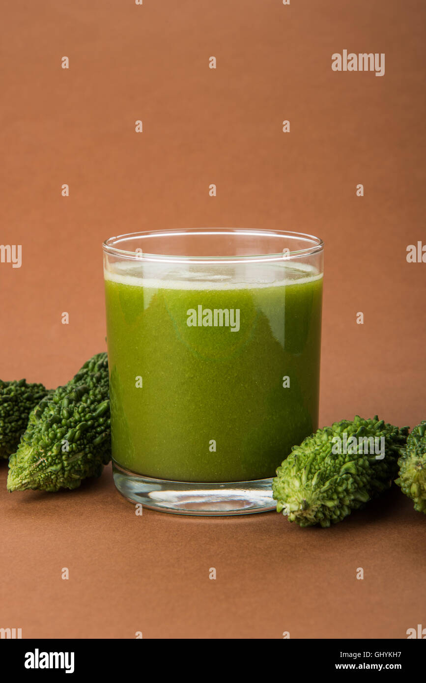 Herbal juice of green momodica in a glass with sliced vegetables ...