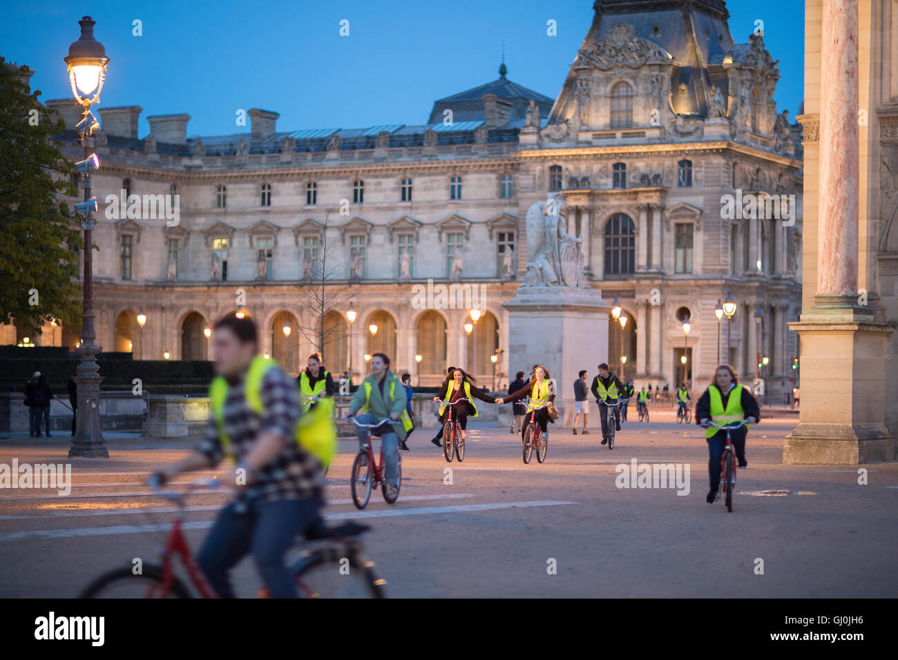 a tour by bike group pass the Arc de Triomphe du Carrousel & Palais du ...