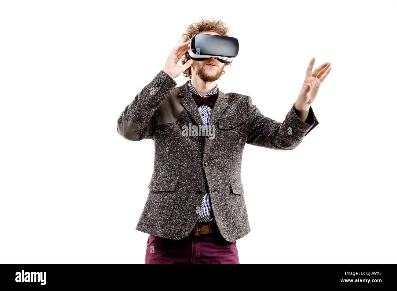Young curly-haired businessman wearing brown suit use a VR headset and ...