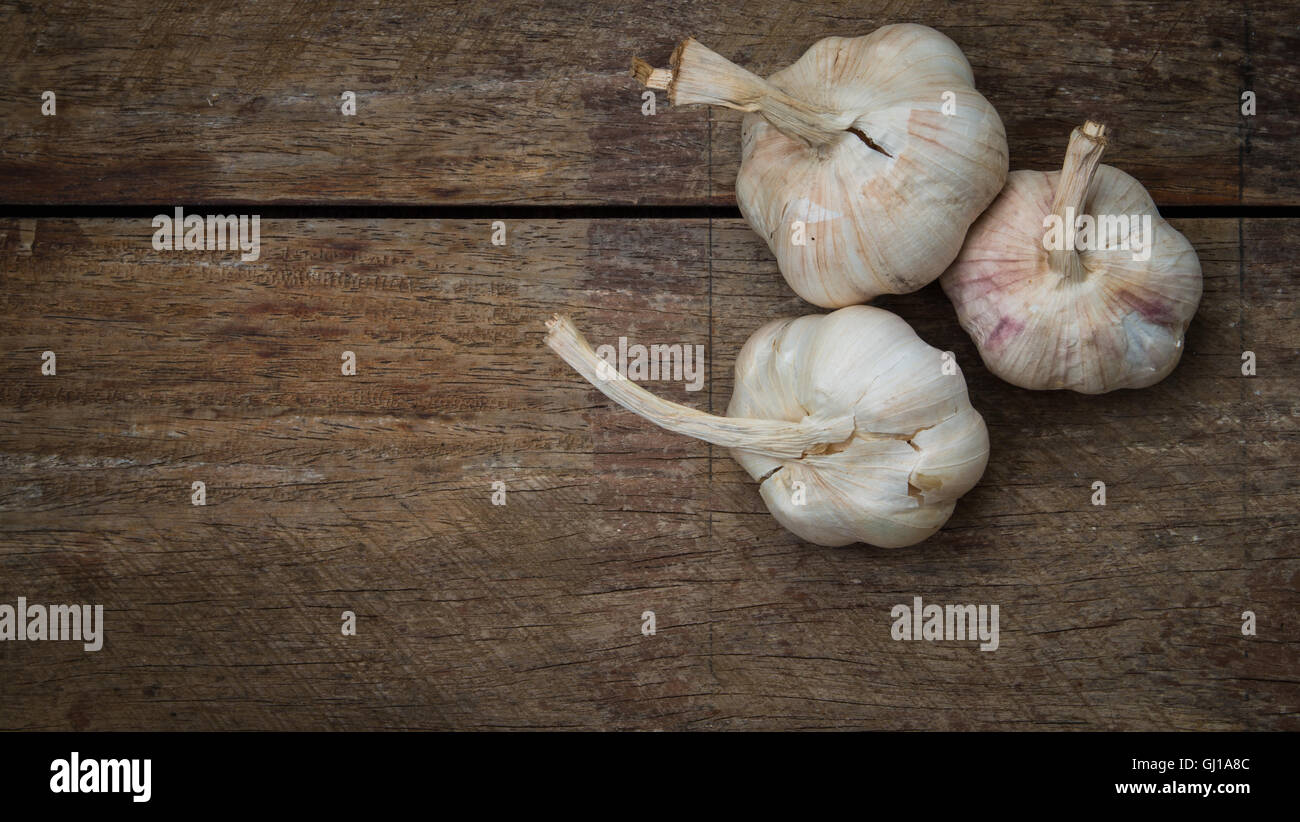 3 garlic lobes on the wooden plate from the top viewpoint Stock Photo ...