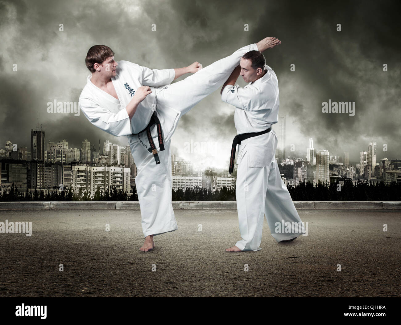 Karate fighters in action on stormy city background Stock Photo - Alamy
