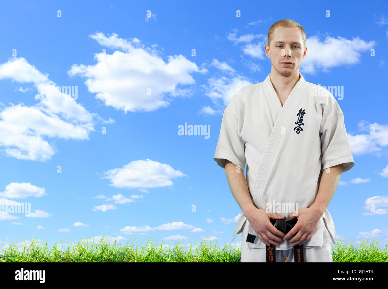 Karate master in kimono on blue sky background Stock Photo - Alamy