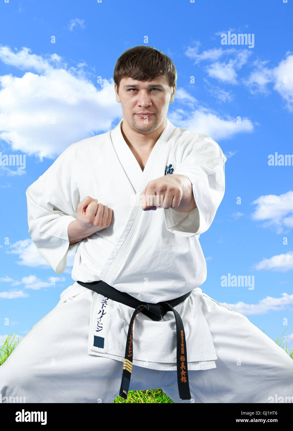 Karate master in kimono on blue sky background Stock Photo - Alamy