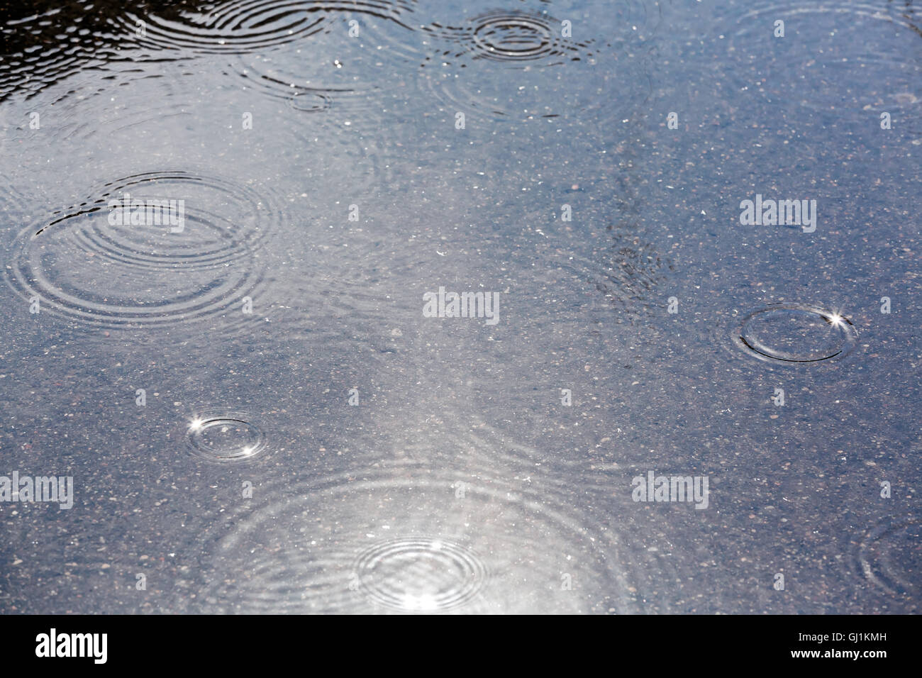 Rain puddles and sun reflection Stock Photo - Alamy