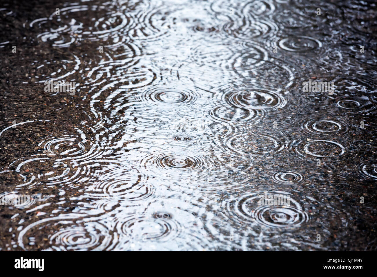 Rain puddles with sky reflection Stock Photo - Alamy