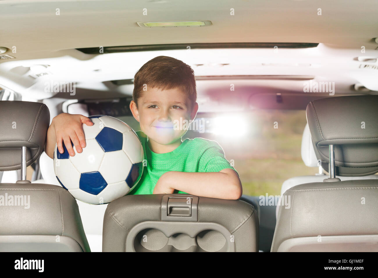 Smiling kid boy holding soccer ball inside the car Stock Photo - Alamy
