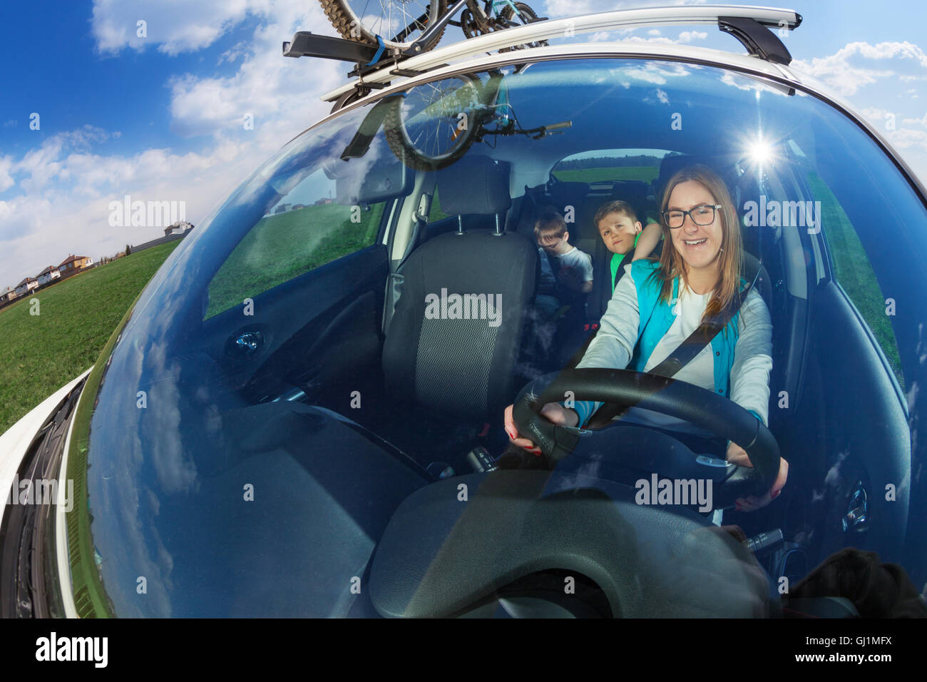 Happy female driver travelling by car with kids Stock Photo - Alamy
