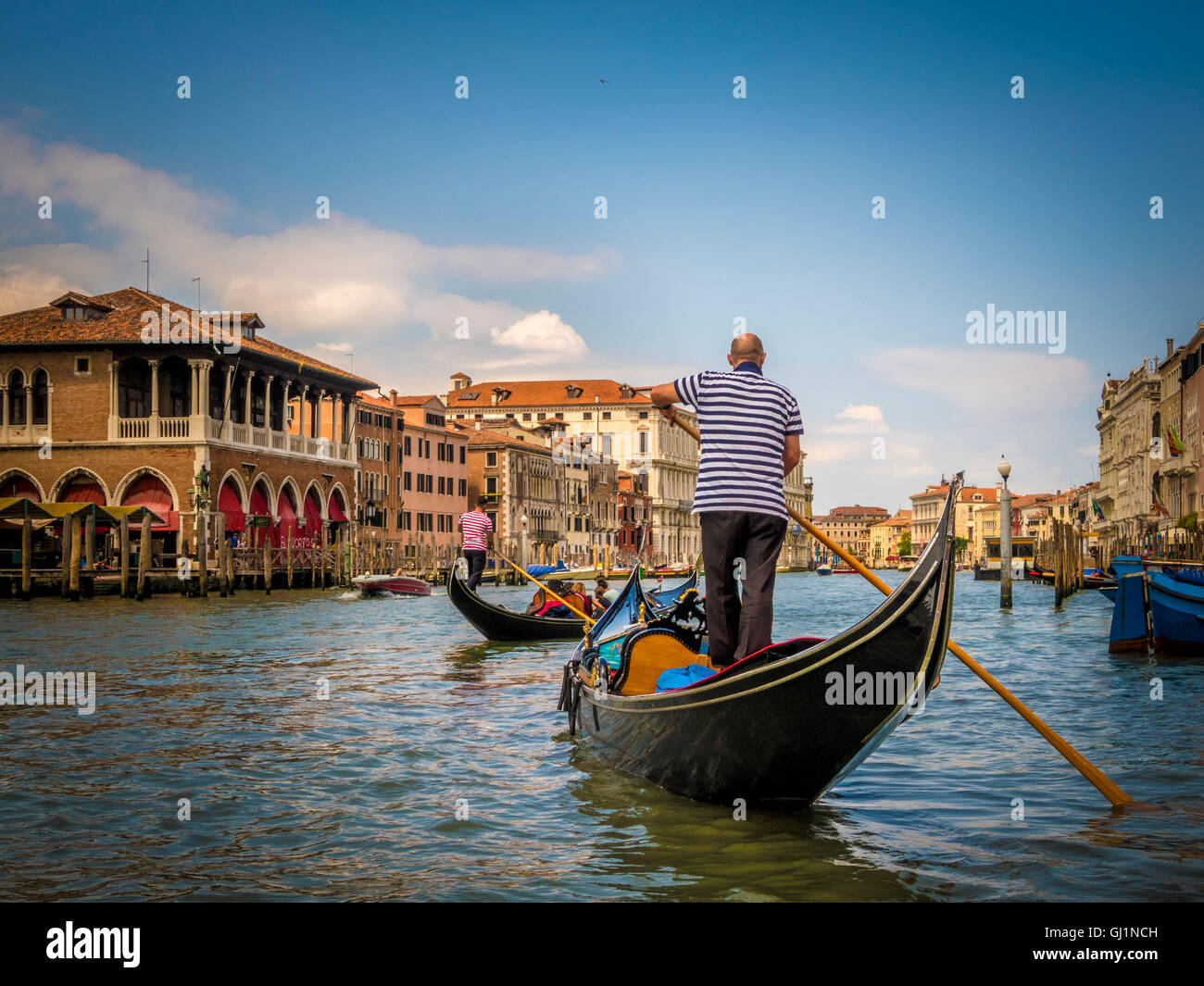Gondolas on the Grand Canal, with gondoliers wearing traditional ...