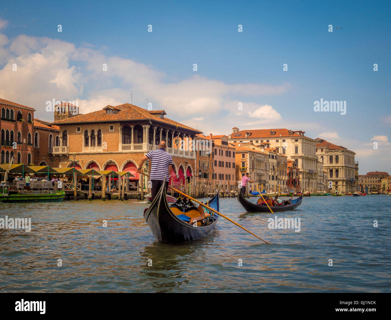 Gondolas on the Grand Canal, with gondoliers wearing traditional ...