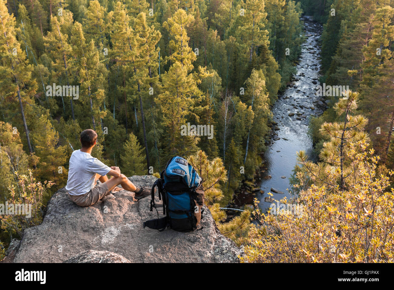 Backpacker sits on rock and look at a beautiful view Stock Photo - Alamy