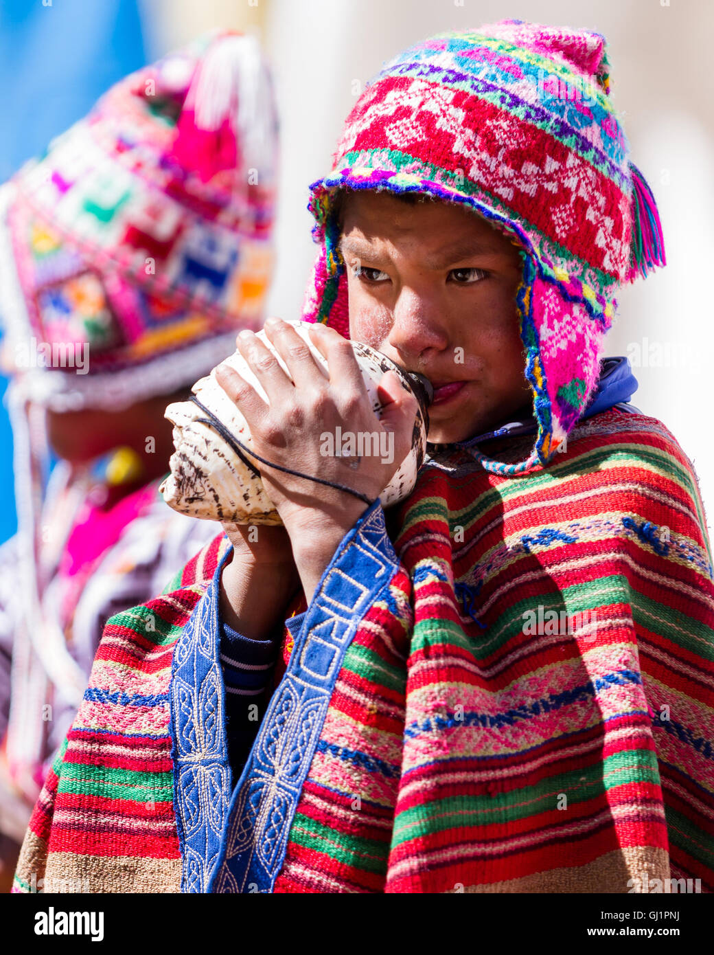 Pisac, Peru - May 15: Young man playing a tune using a conch shell as ...