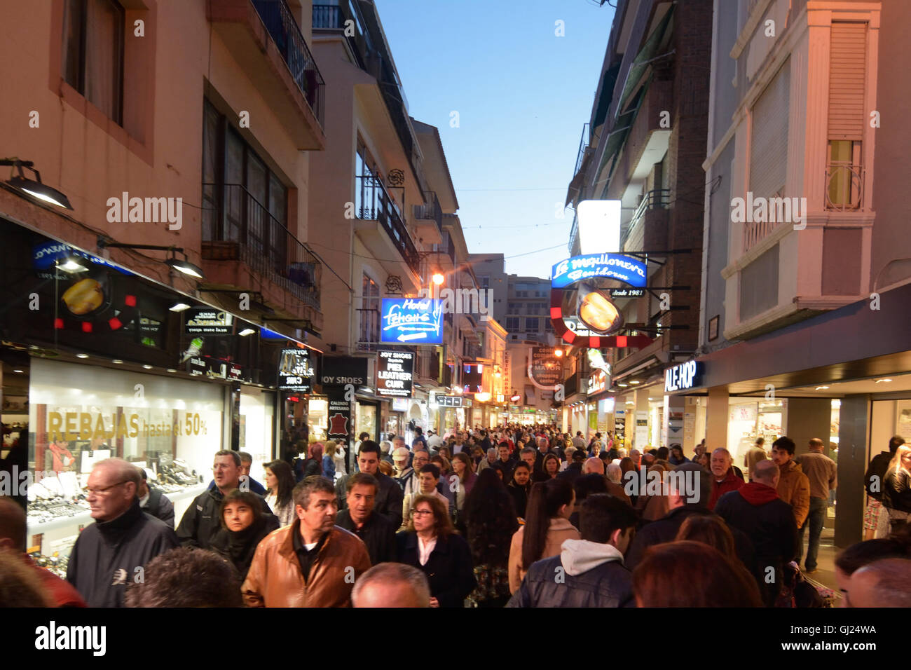 Spain, Benidorm, crowds of people walking in downtown pedestrian street ...