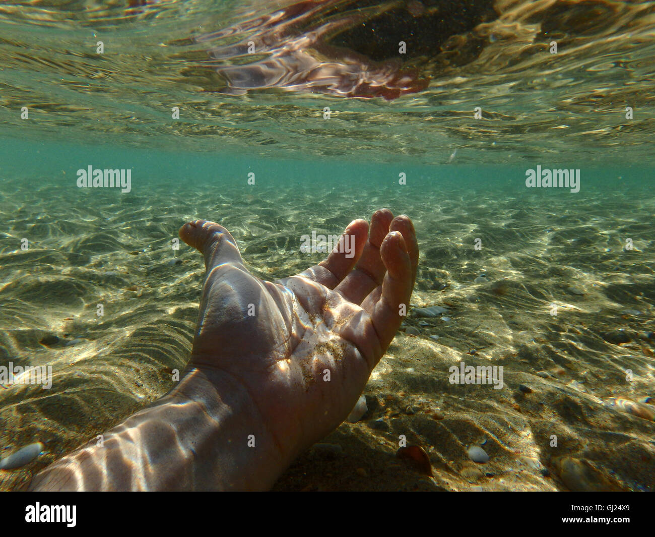 Underwater hand, sea, sand and light Stock Photo - Alamy