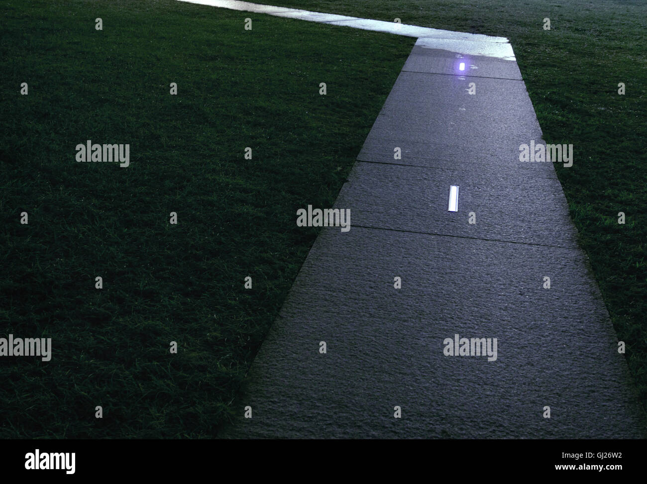 Bending pathway lit up at night Stock Photo - Alamy