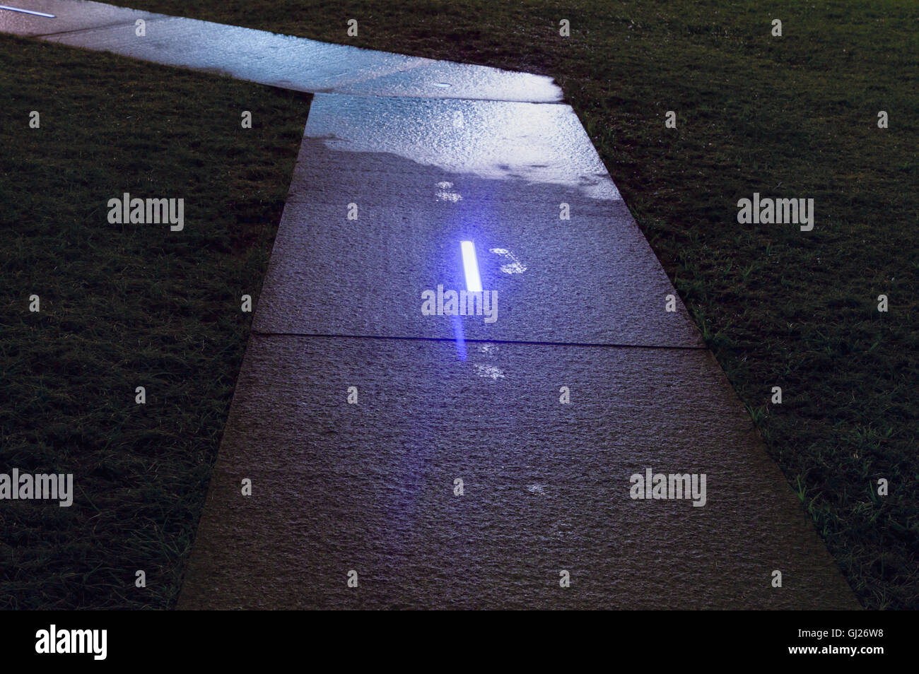 Wet footprints on a bending pathway at night Stock Photo - Alamy