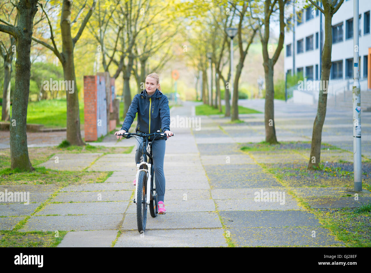 Young woman with bike in spring city Stock Photo - Alamy