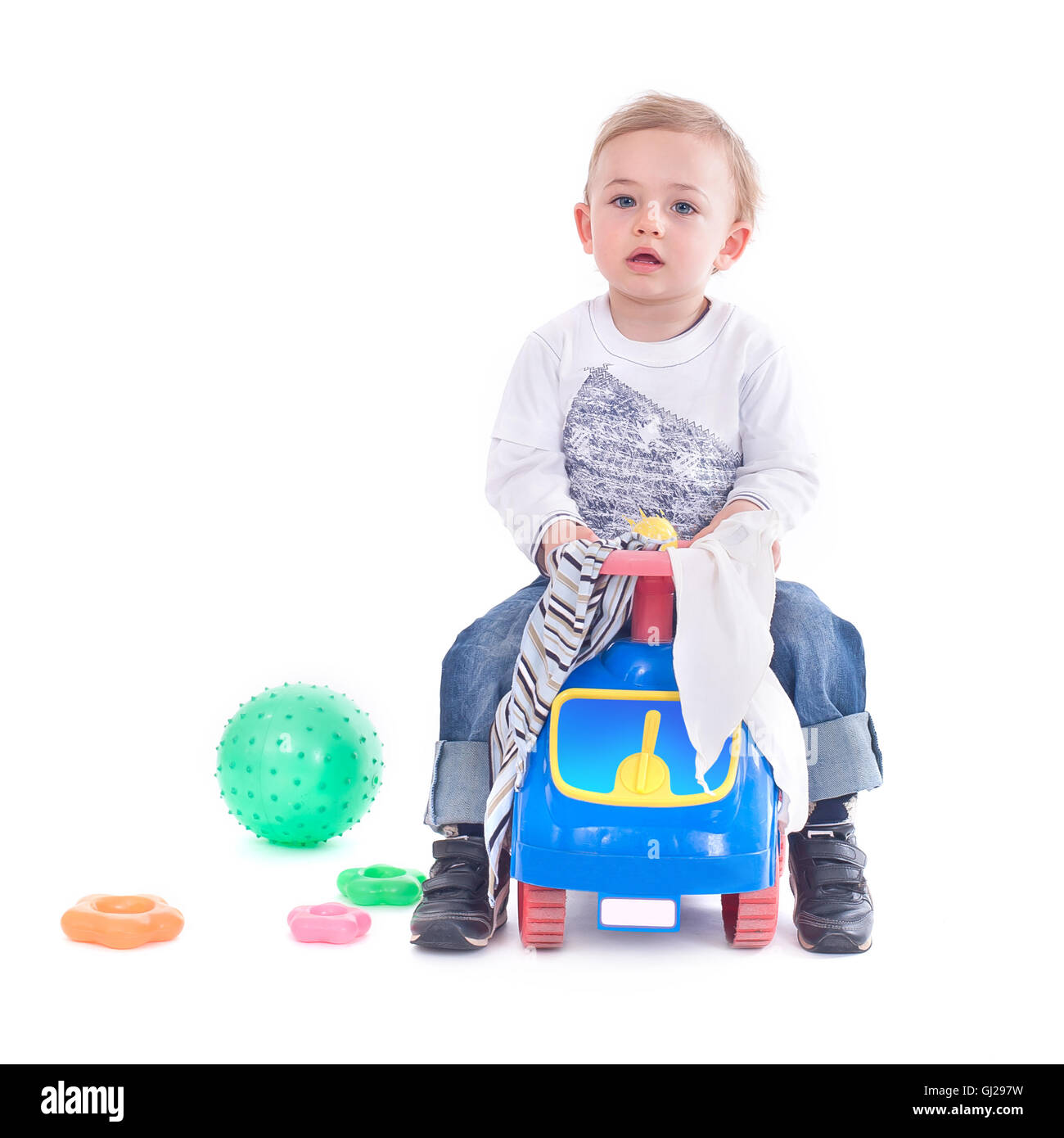 Young boy riding a toy car Stock Photo - Alamy