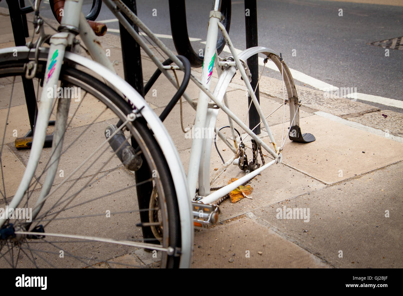 An old bicycle with lost, stolen, or missing back wheel attached to a ...