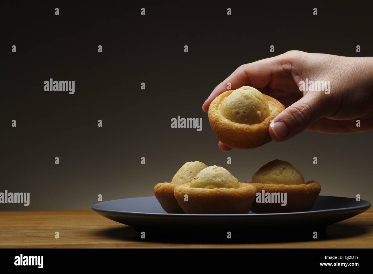 Hand getting a freshly baked Filipino muffin known as "kabayan" from a ...