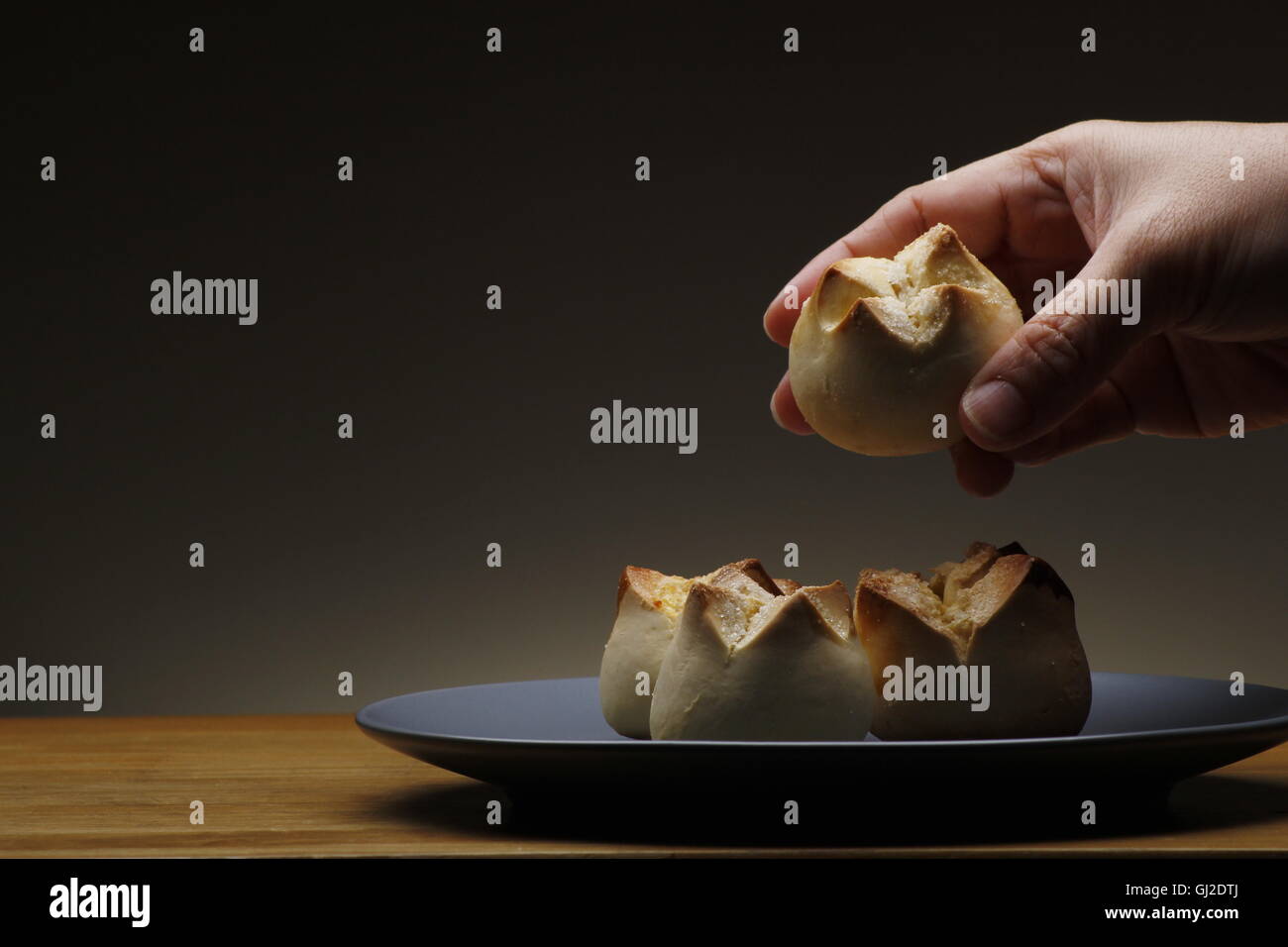 Hand getting a freshly baked Filipino sweet bread known as "putok" from ...