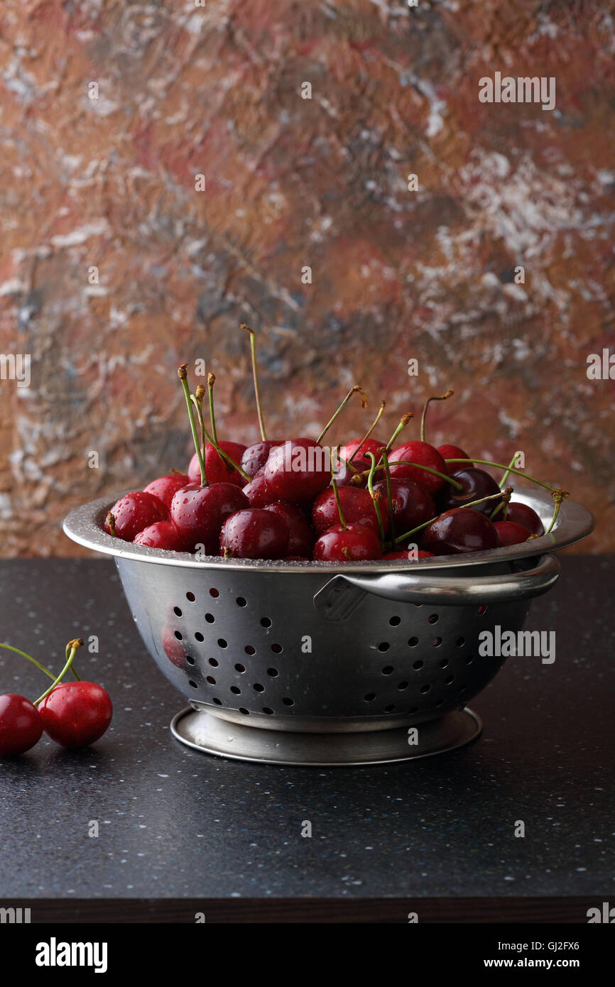 Crop of fresh cherry in colander, fruits closeup Stock Photo - Alamy