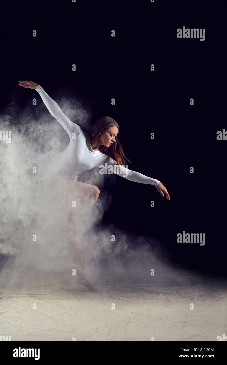 Ballerina dancing with flour on a black background Stock Photo - Alamy