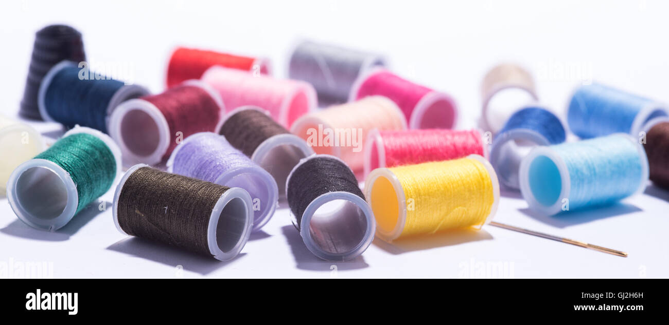 colorfull plastic yarn spools on white background Stock Photo - Alamy