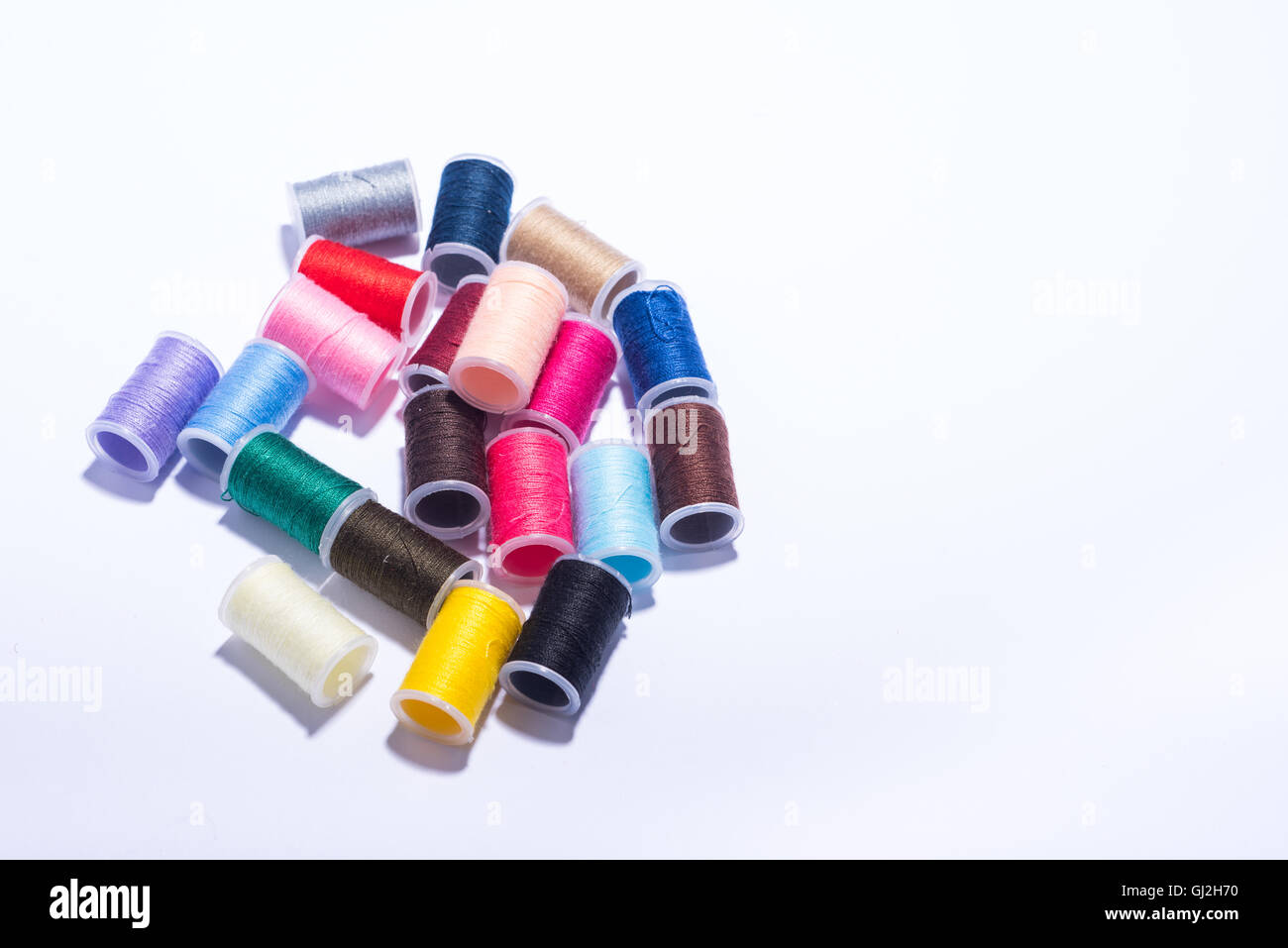 colorfull plastic yarn spools on white background Stock Photo - Alamy