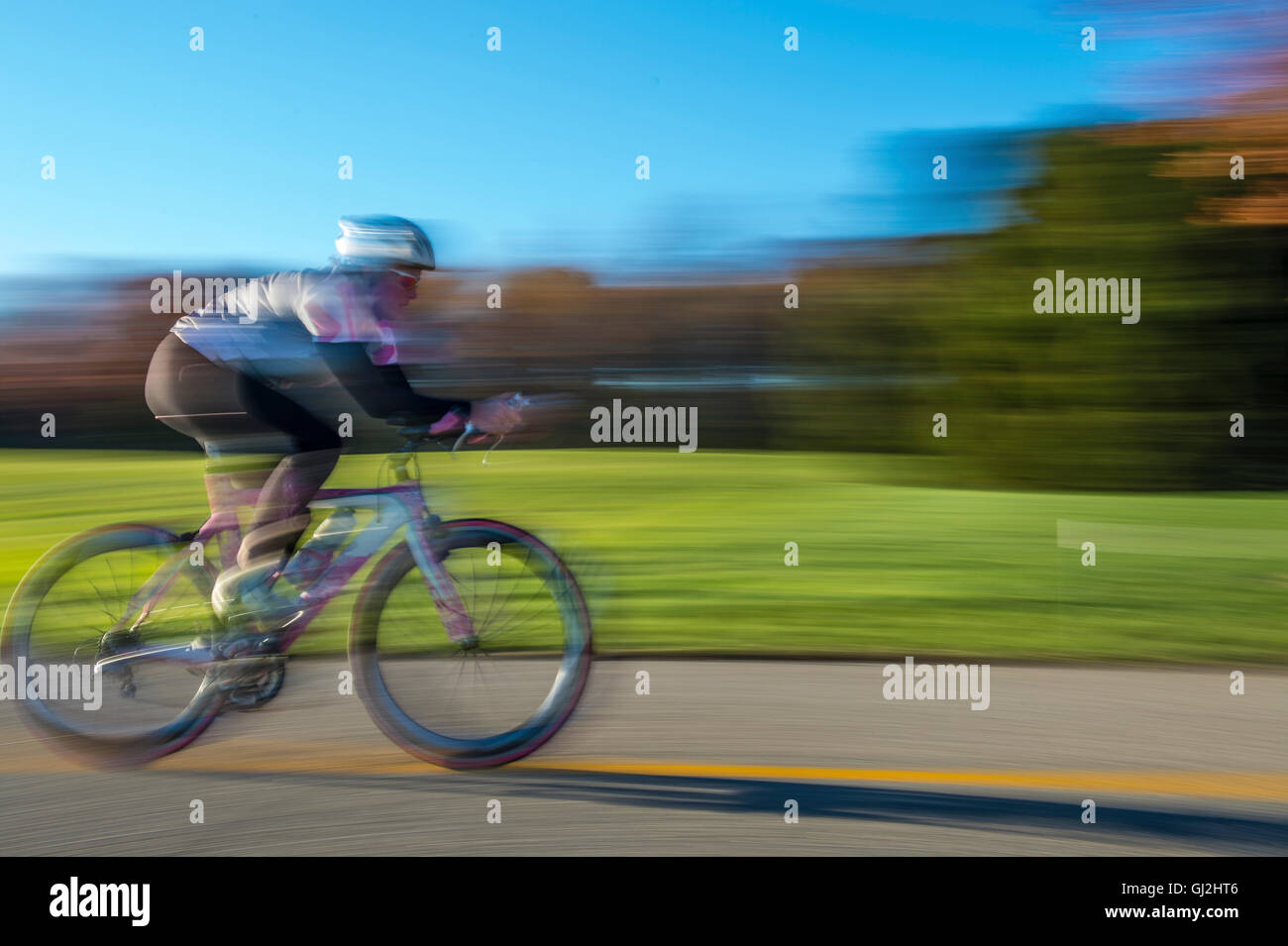 Blurred motion side view of cyclist cycling Stock Photo - Alamy