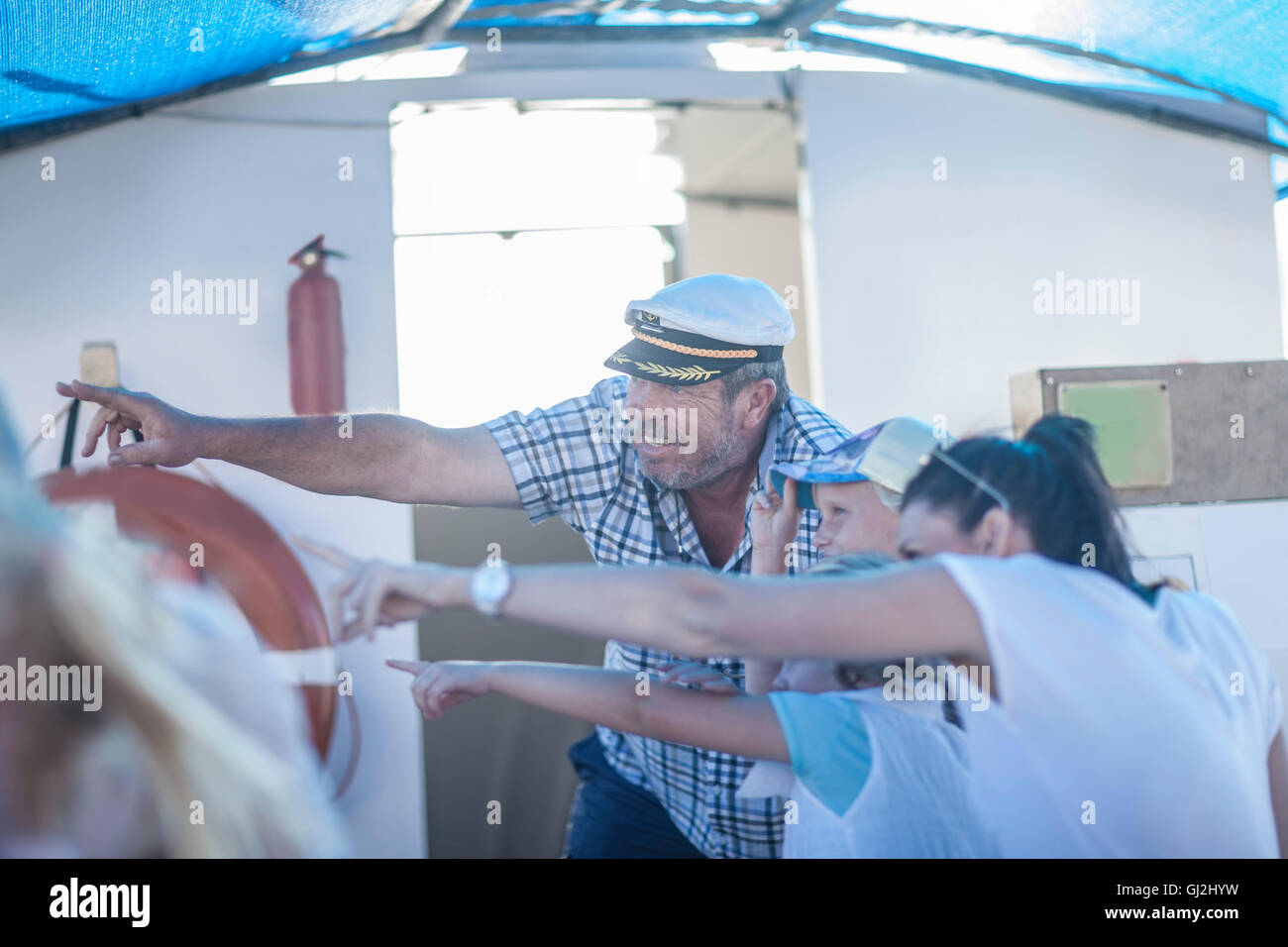 Captain with tourists pointing on boat trip, Cape Town, South Africa ...