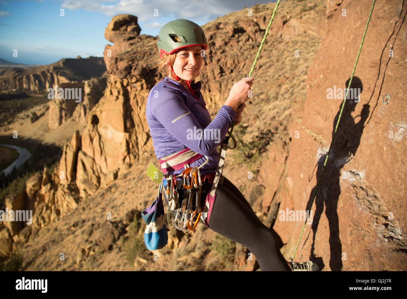 Woman rock climbing looking at camera smiling Stock Photo - Alamy