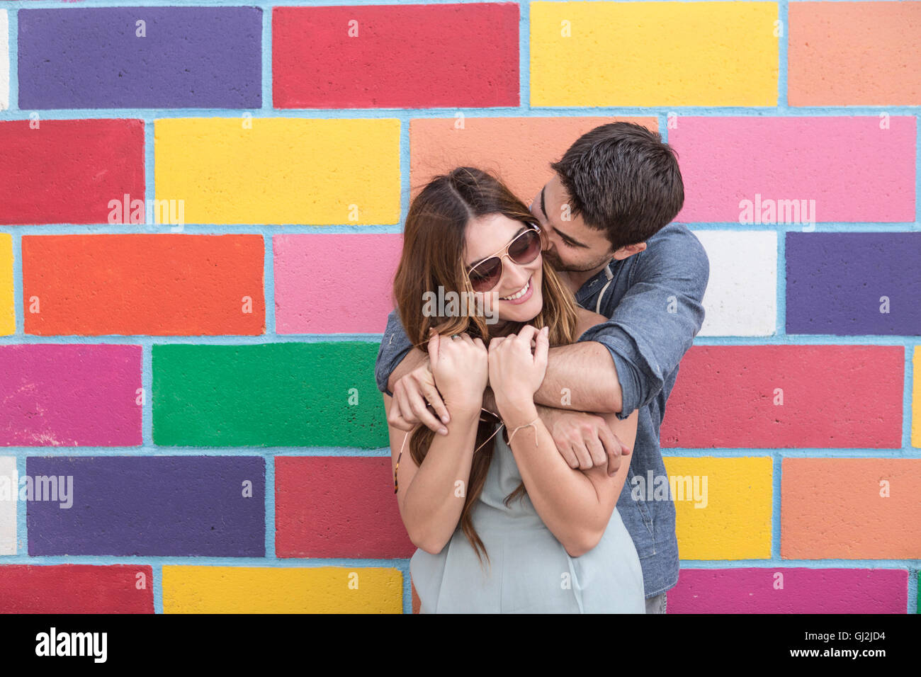 Couple in front of colourful tiled wall hugging, Coney island, Brooklyn ...