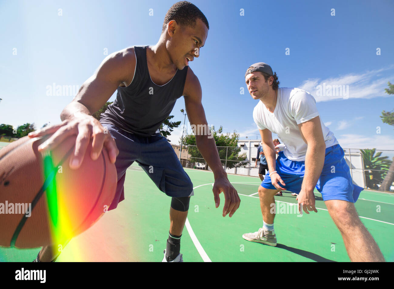 Two male friends playing basketball on outdoor court Stock Photo - Alamy