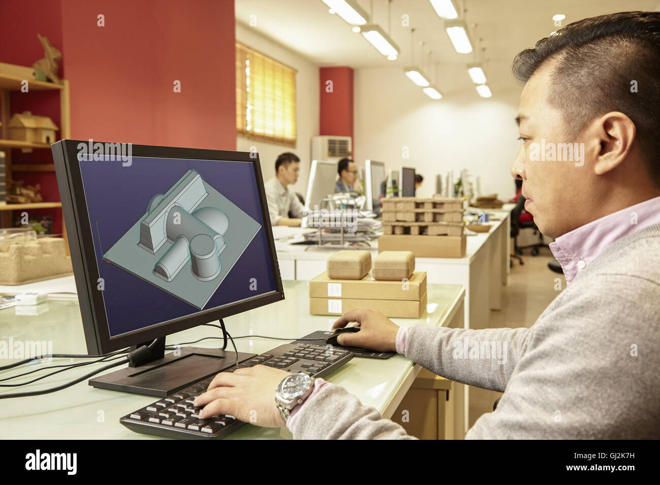 Male technician working on computer in printing and packaging factory ...
